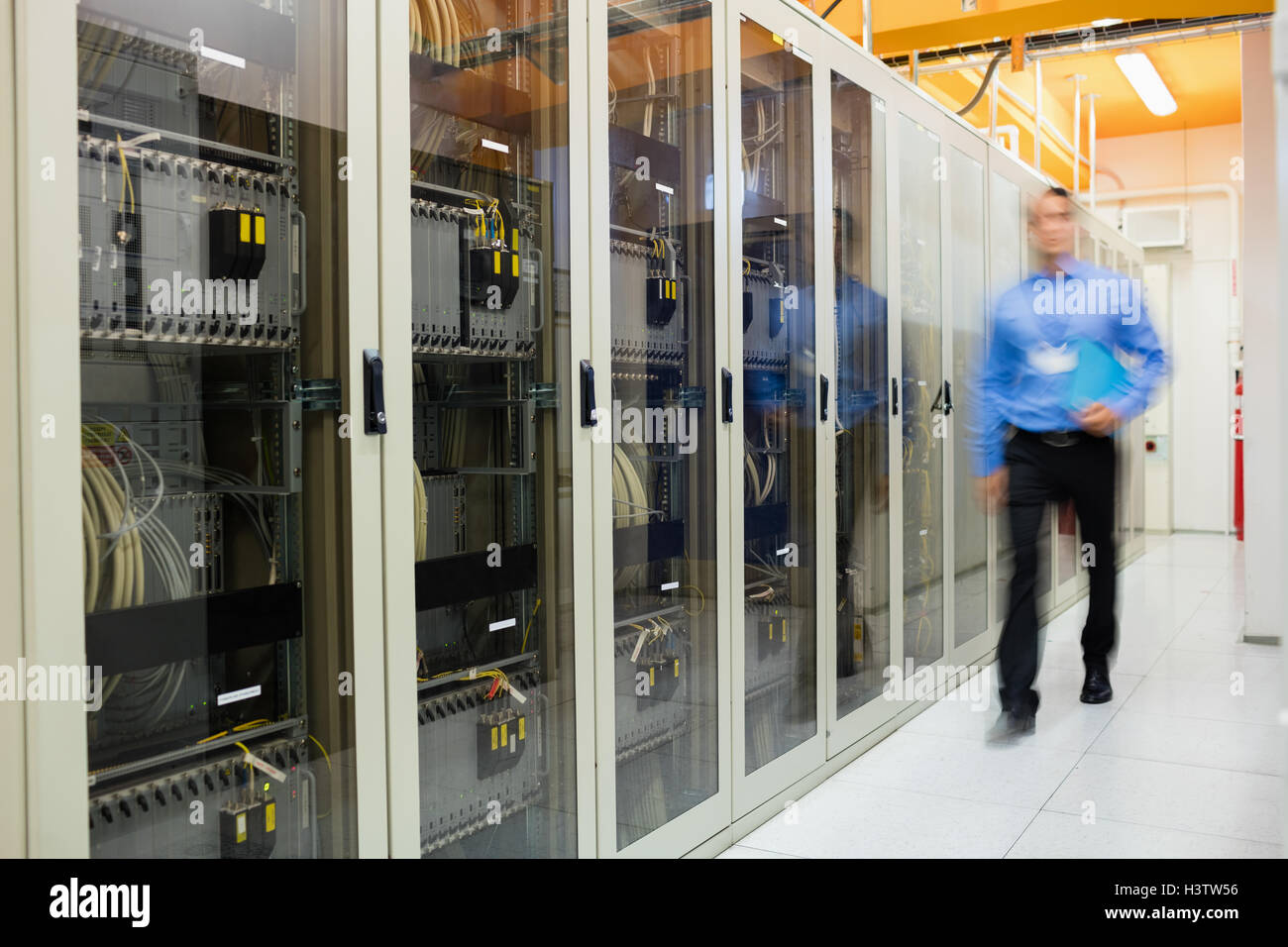 Technician walking in server room Stock Photo - Alamy