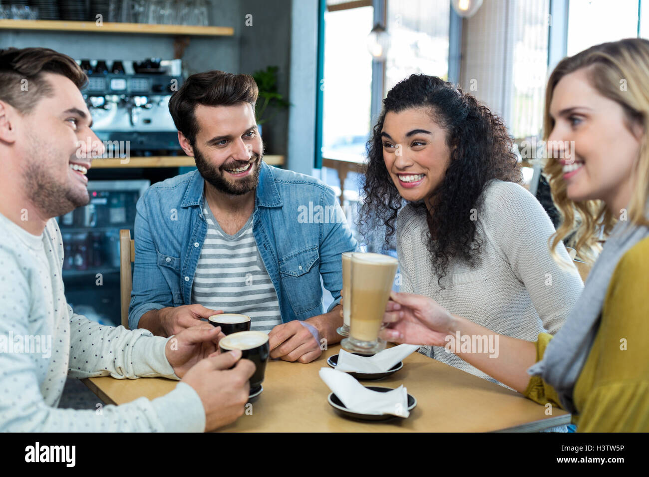 Smiling friends having a cup of coffee and cold coffee in caf├⌐ Stock ...