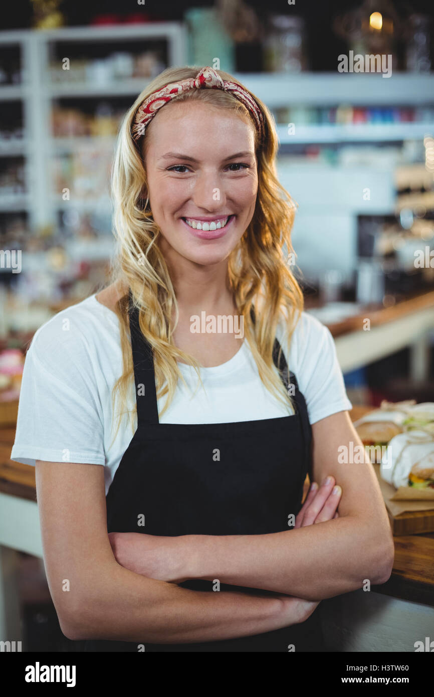 Portrait of smiling waitress standing with arms crossed Stock Photo - Alamy