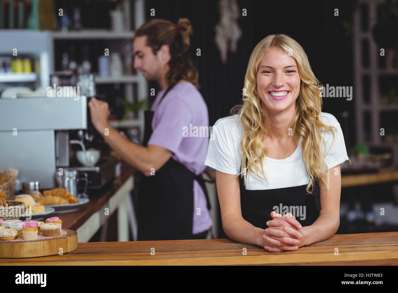 Portrait of smiling waitress standing at counter Stock Photo - Alamy