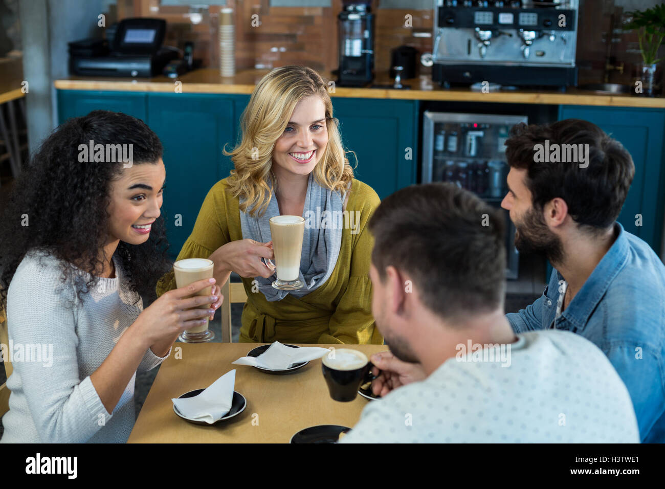 Smiling friends having a cup of coffee and cold coffee in caf├⌐ Stock ...