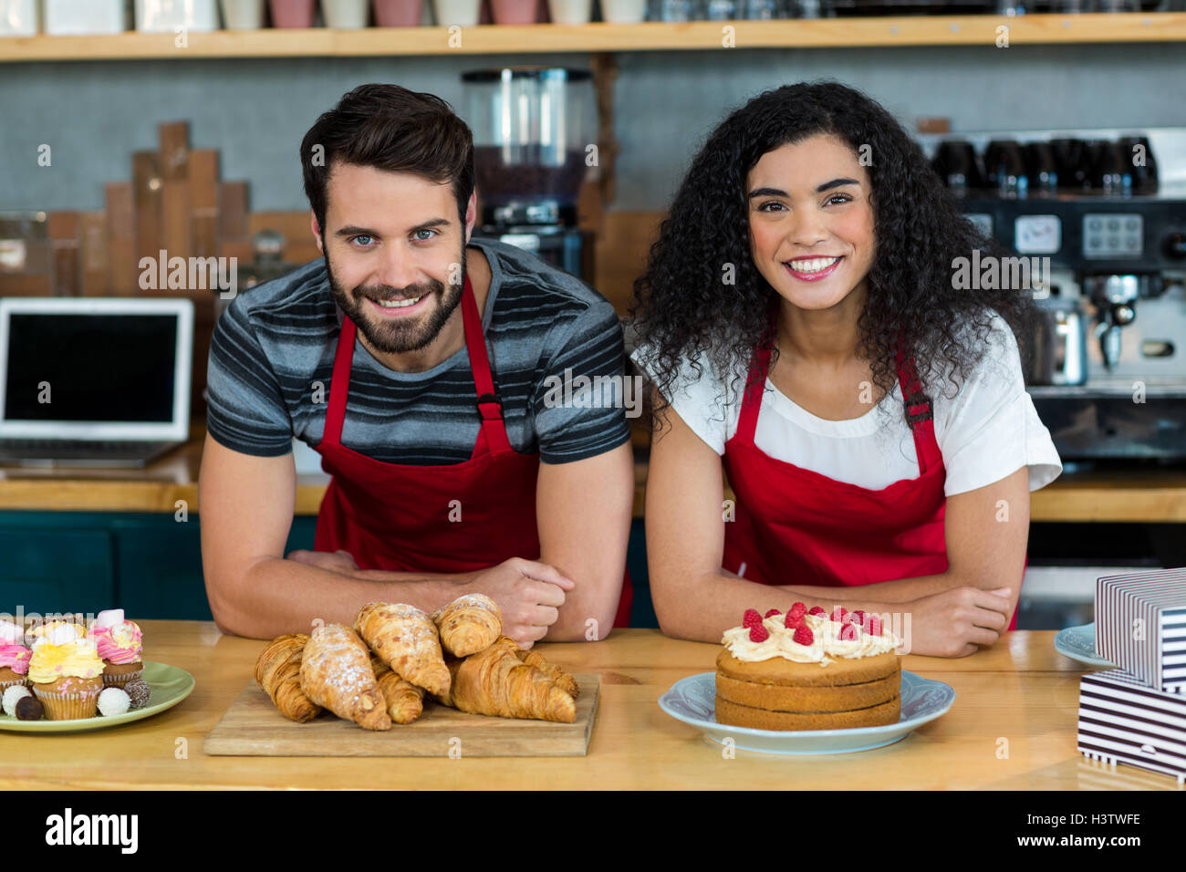 Portrait of waiter and waitress leaning on counter Stock Photo - Alamy