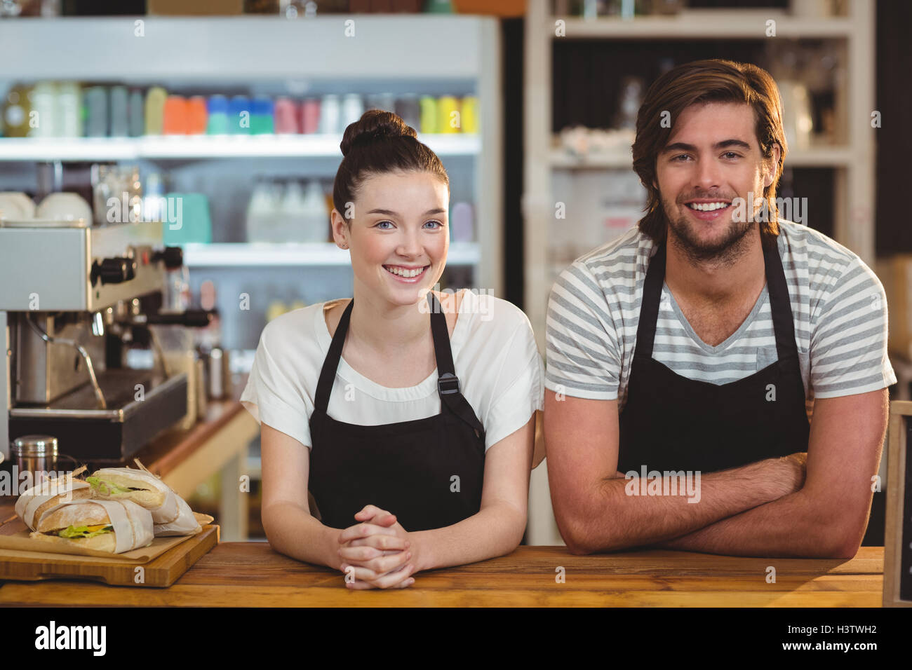 Portrait of smiling waiter and waitress standing at counter Stock Photo ...