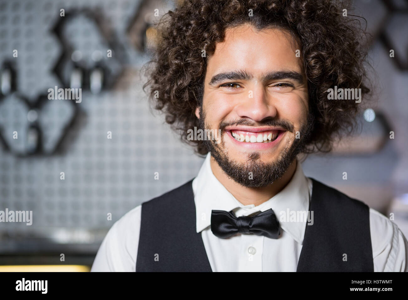 Smiling bartender standing in bar counter Stock Photo - Alamy