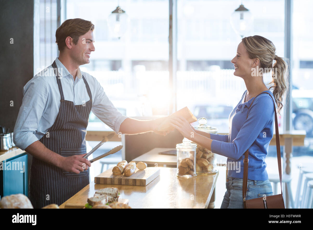 Waiter giving parcel to customer at counter Stock Photo - Alamy