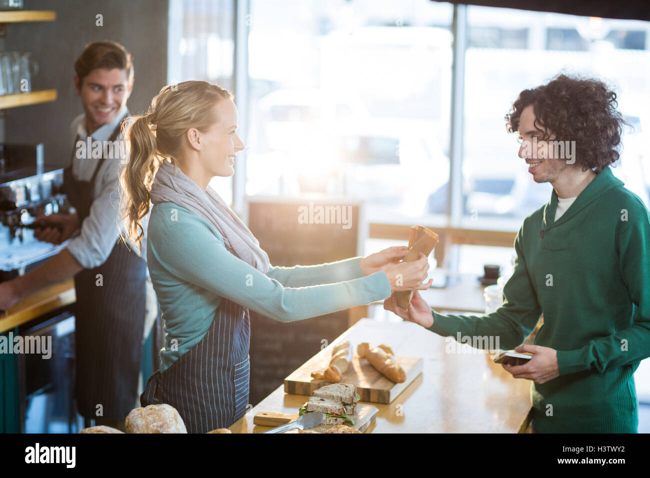 Waitress giving parcel to customer at counter Stock Photo - Alamy