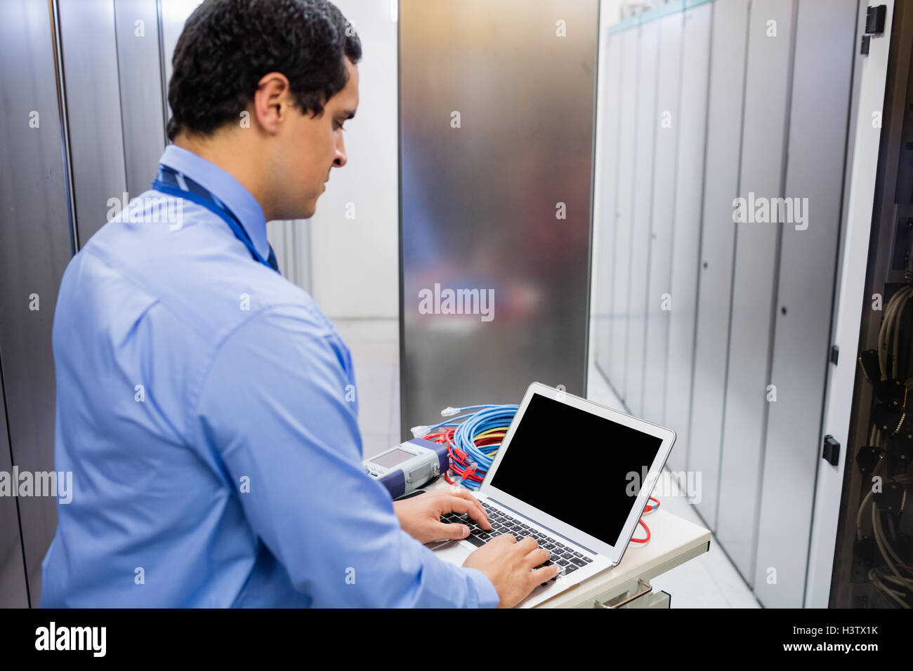 Technician using laptop Stock Photo - Alamy