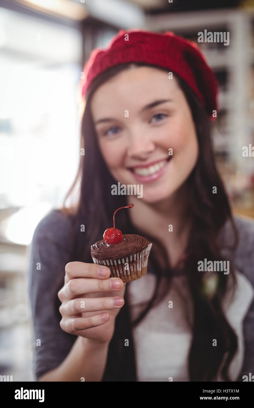 Portrait of smiling woman holding cupcake Stock Photo - Alamy