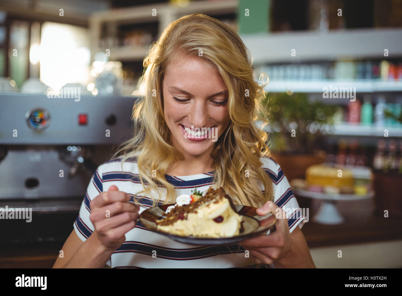 Smiling woman eating dessert in cafe Stock Photo - Alamy