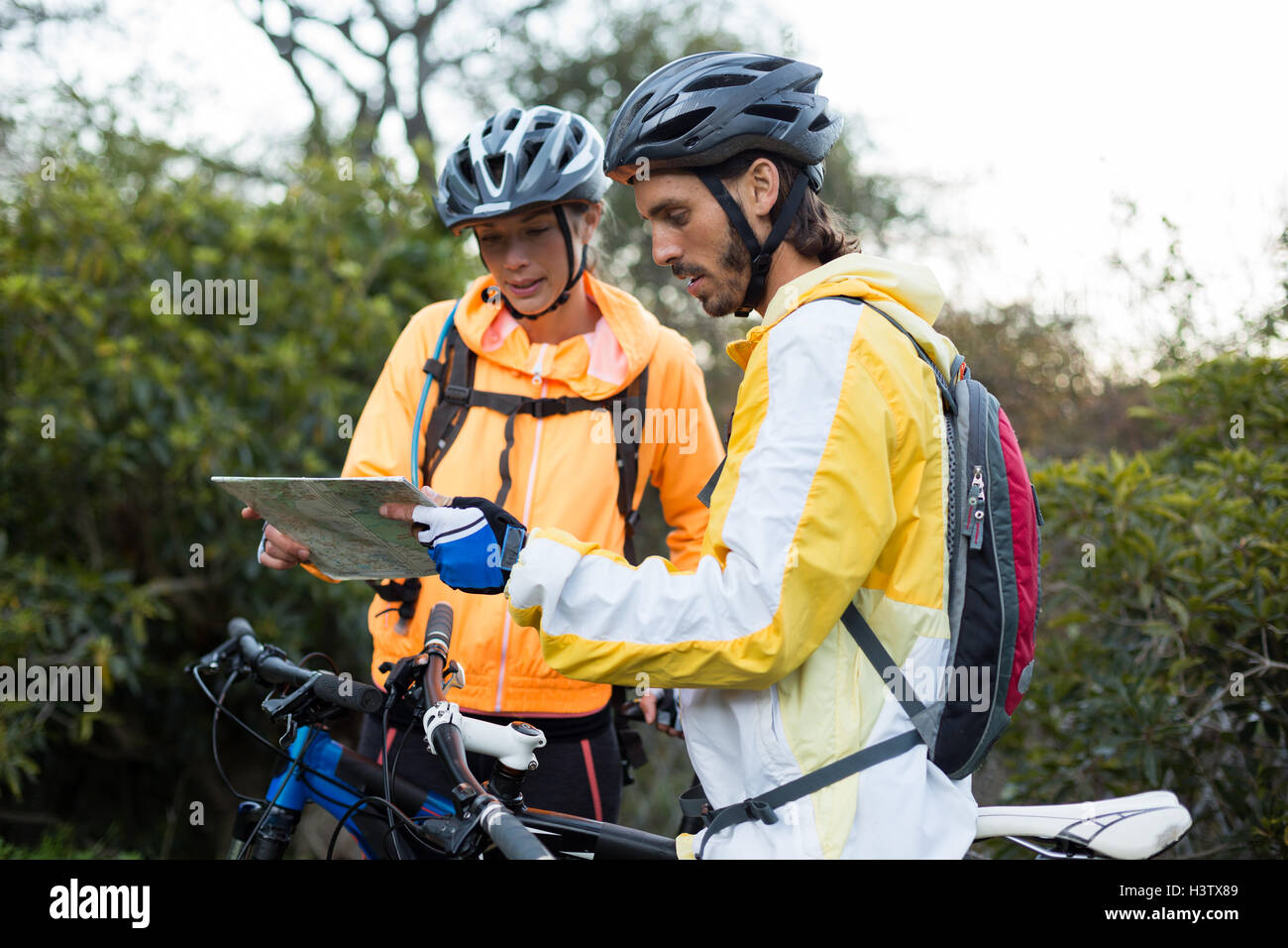 Biker couple looking at a map Stock Photo - Alamy