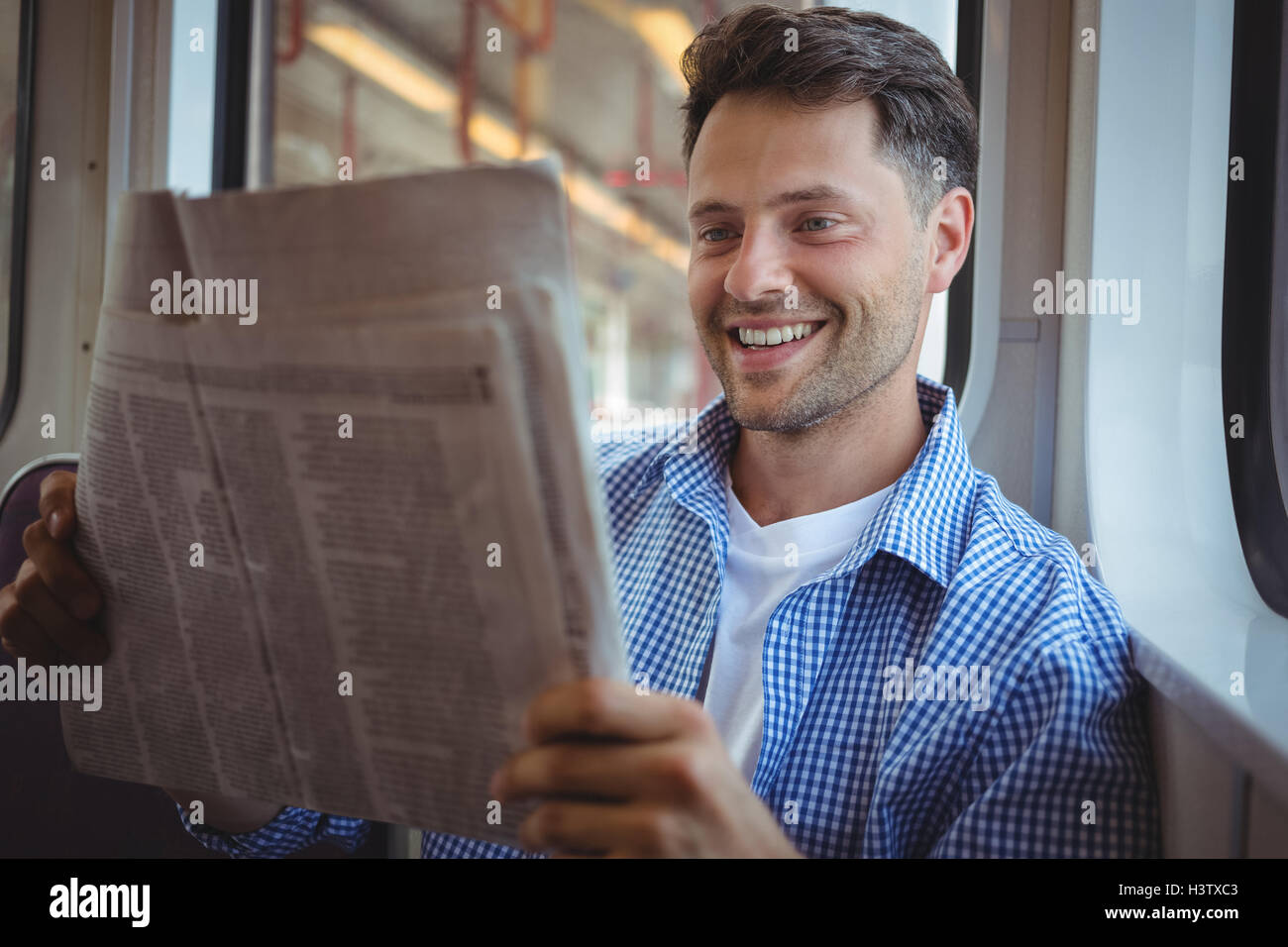 Handsome man reading newspaper Stock Photo - Alamy