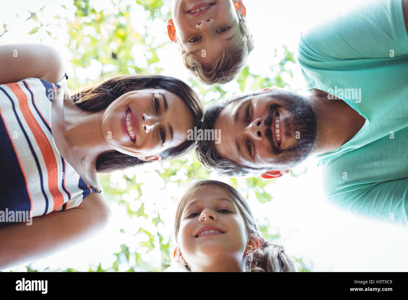 Family forming huddle against sky Stock Photo - Alamy
