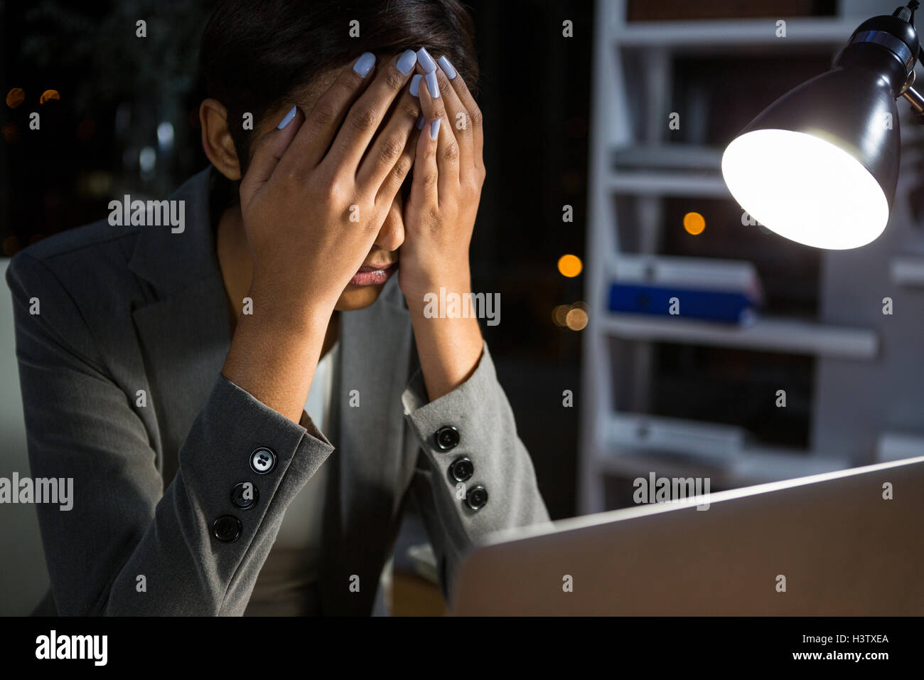 Stressed businesswoman sitting at her desk Stock Photo - Alamy
