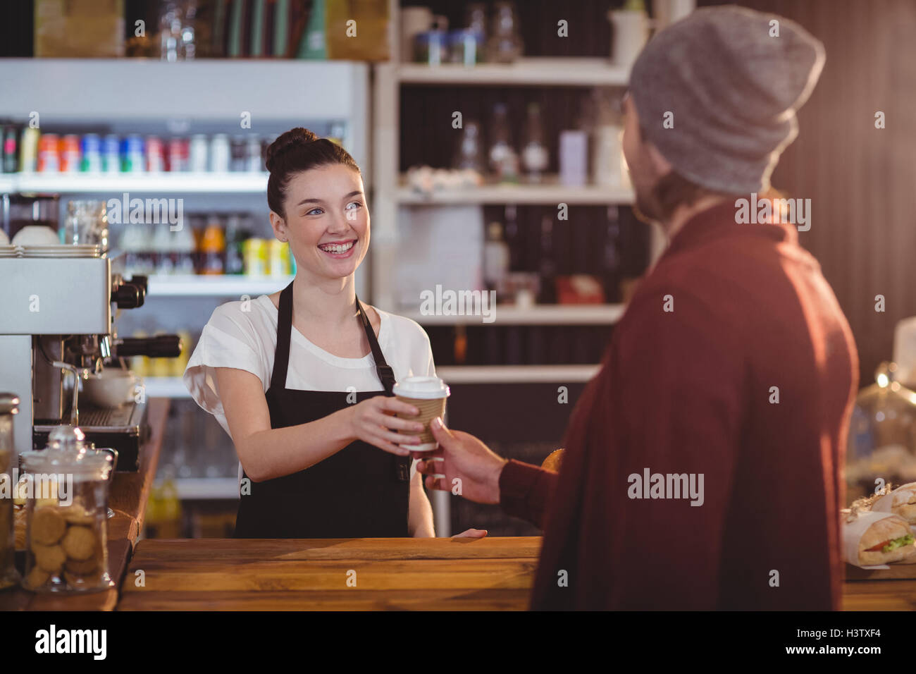 Waitress offering a cup of coffee Stock Photo - Alamy