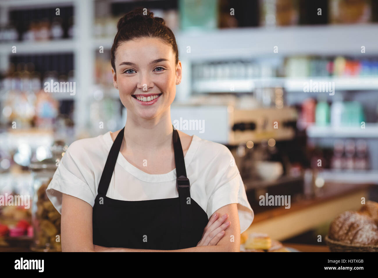 Portrait of smiling waitress standing with arms crossed Stock Photo - Alamy