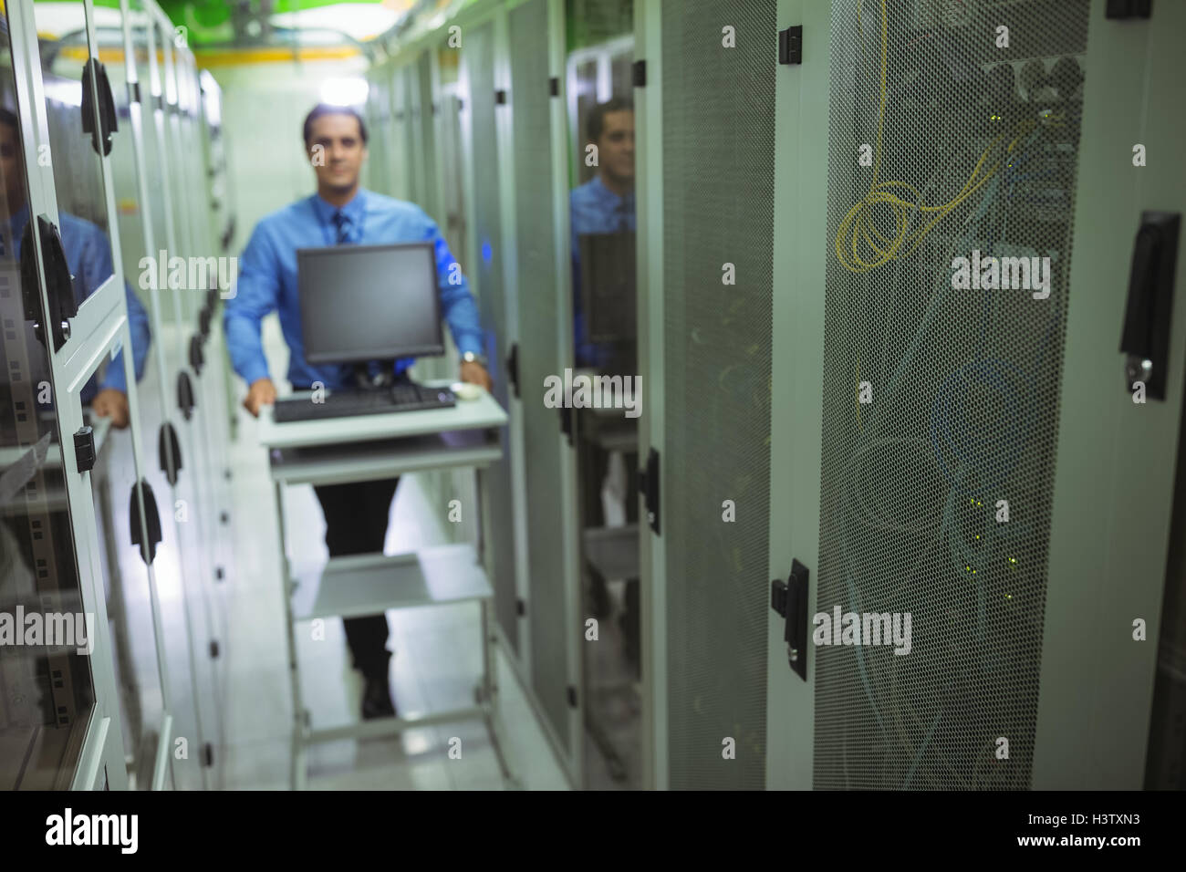 Technician walking with personal computer in hallway Stock Photo - Alamy