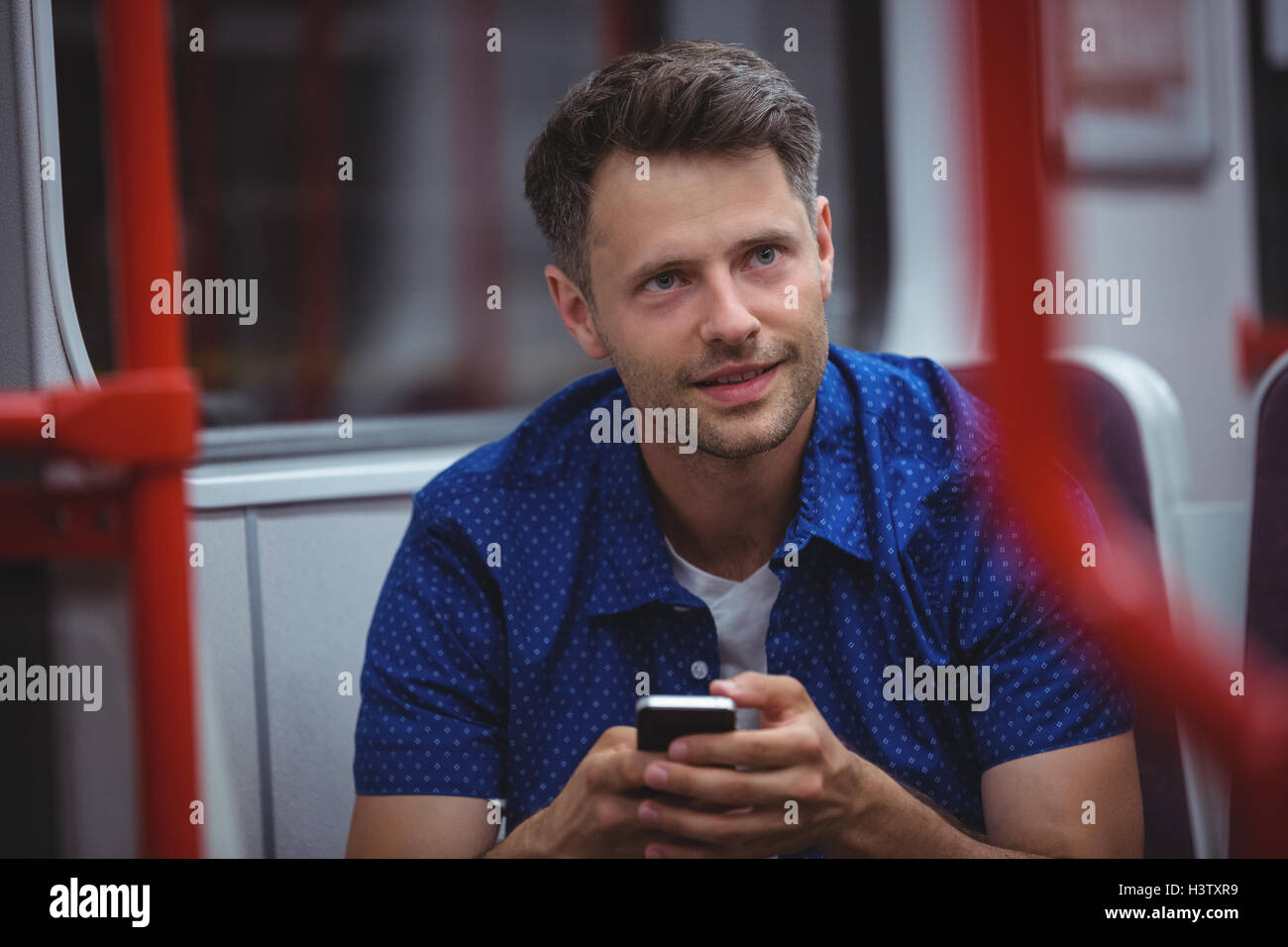Handsome man using mobile phone in train Stock Photo - Alamy