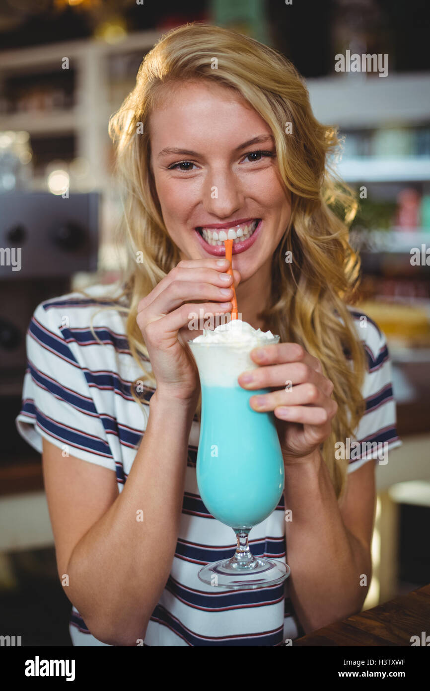 Portrait of woman drinking milkshake with a straw Stock Photo - Alamy