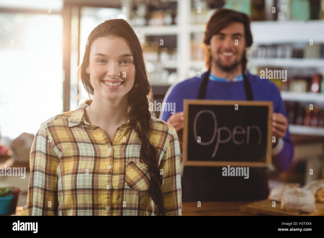Waiter holding open signboard and standing with customer Stock Photo ...