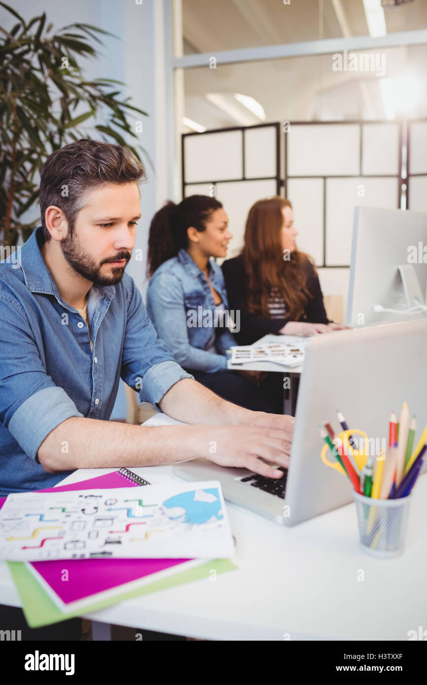 Creative business people using technologies at desk Stock Photo - Alamy