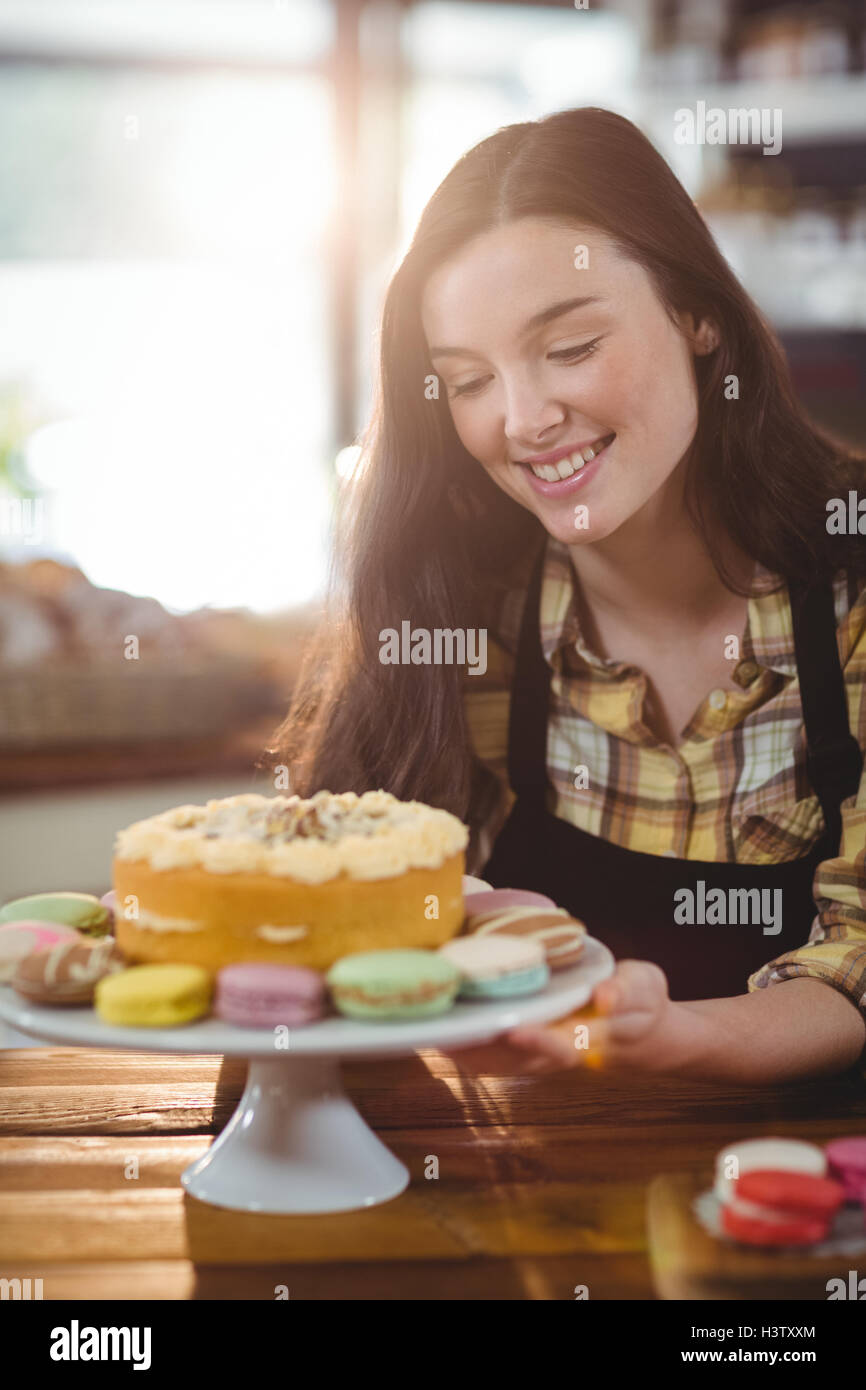 Waitress holding dessert on cake stand in cafe Stock Photo - Alamy