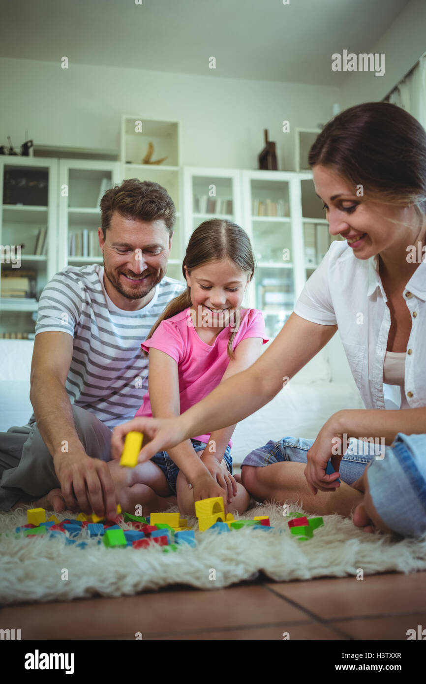 Parents and daughter playing with building blocks Stock Photo - Alamy