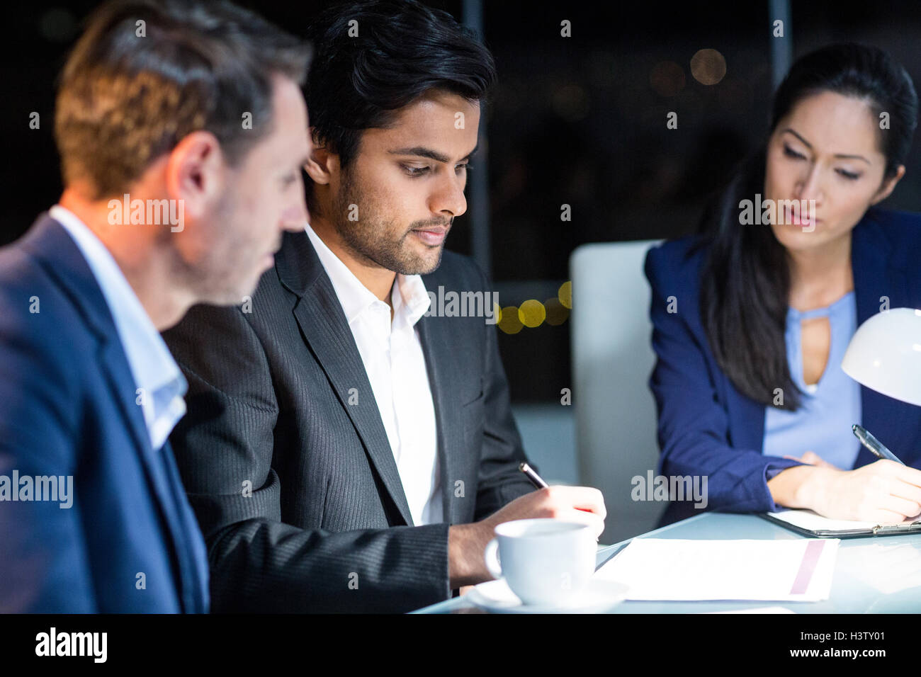 Group of businesspeople looking at document Stock Photo - Alamy