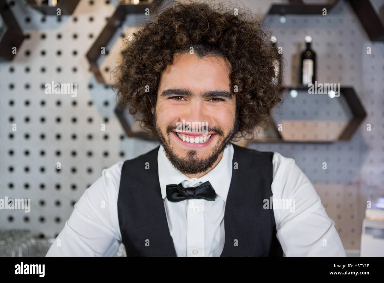 Smiling bartender standing in bar counter Stock Photo - Alamy