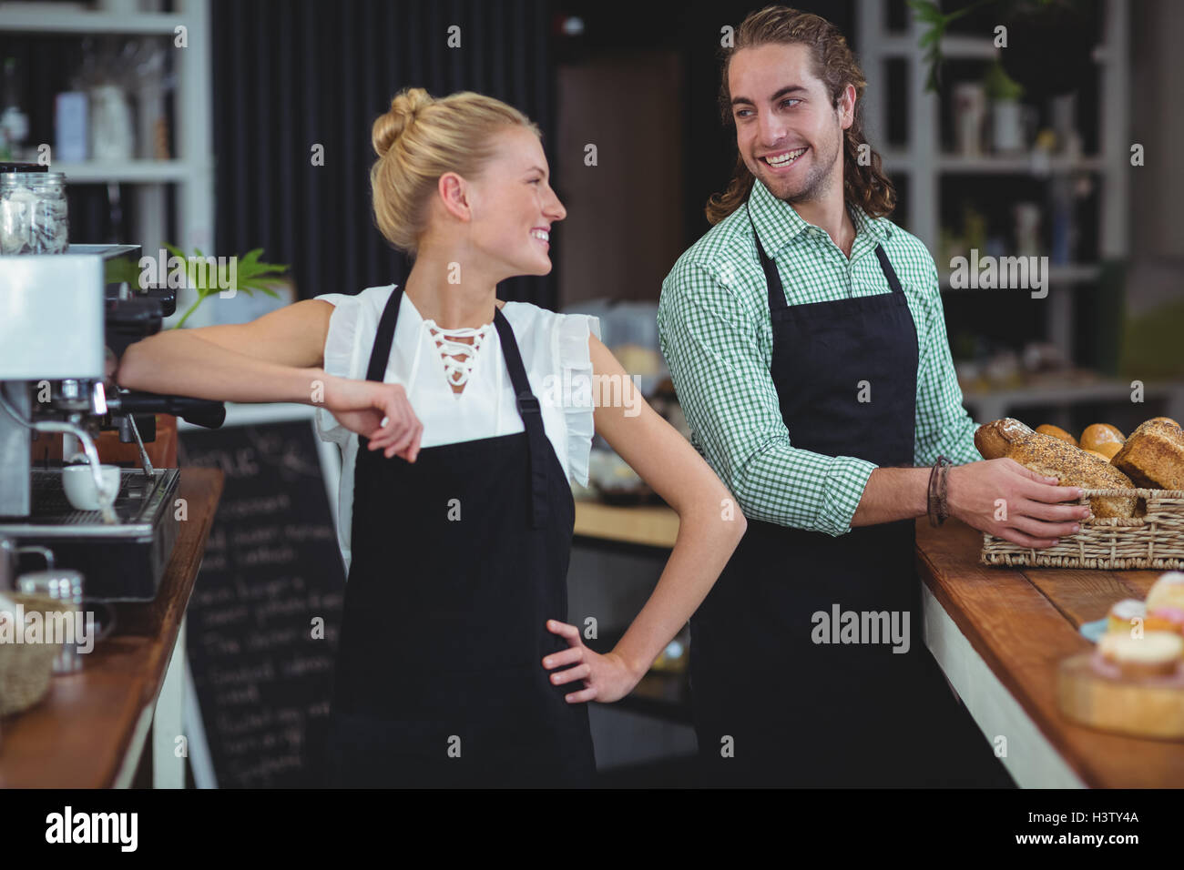 Waiter and waitress smiling at each other Stock Photo - Alamy