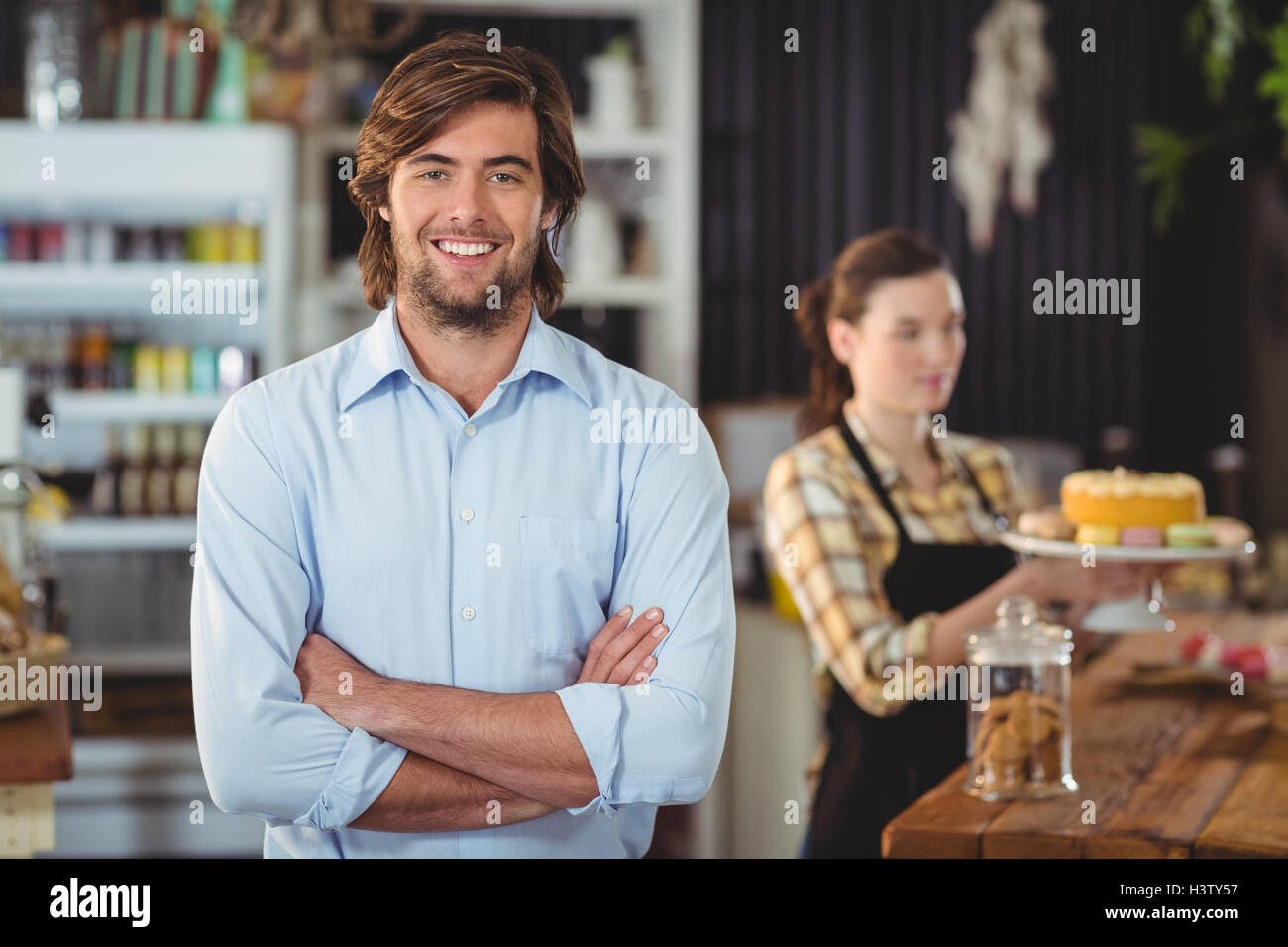 Smiling man standing behind the counter Stock Photo - Alamy