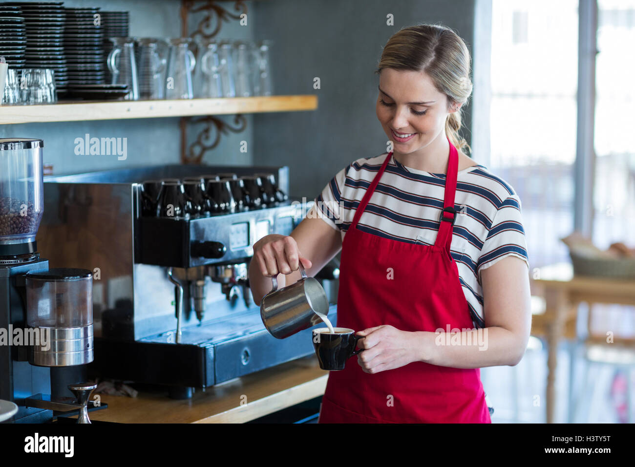 Waitress making cup of coffee at counter in cafe Stock Photo - Alamy