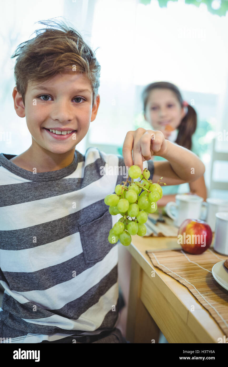 Smiling boy holding a bunch of grapes Stock Photo - Alamy
