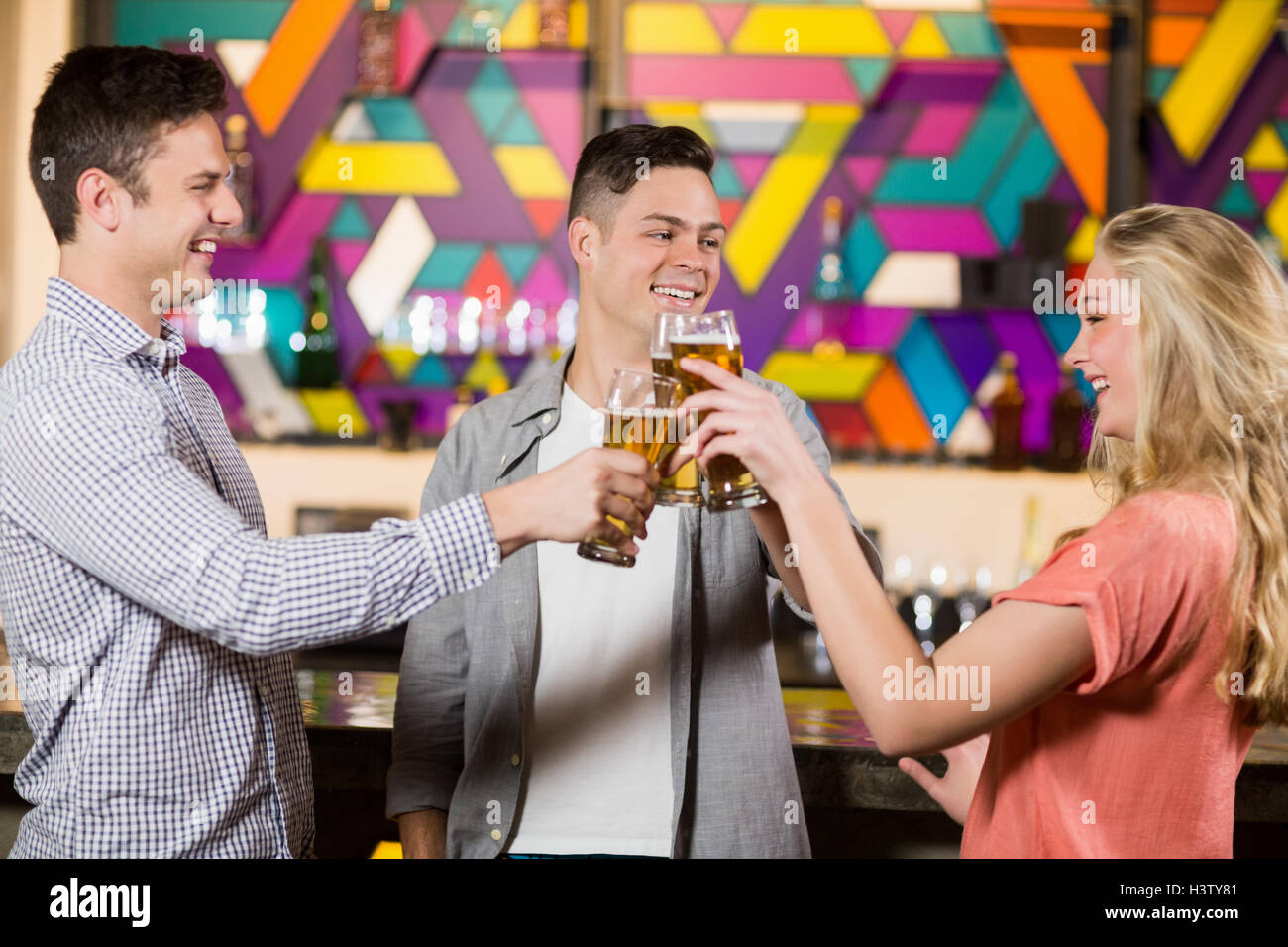 Three friends toasting glasses of beer Stock Photo - Alamy
