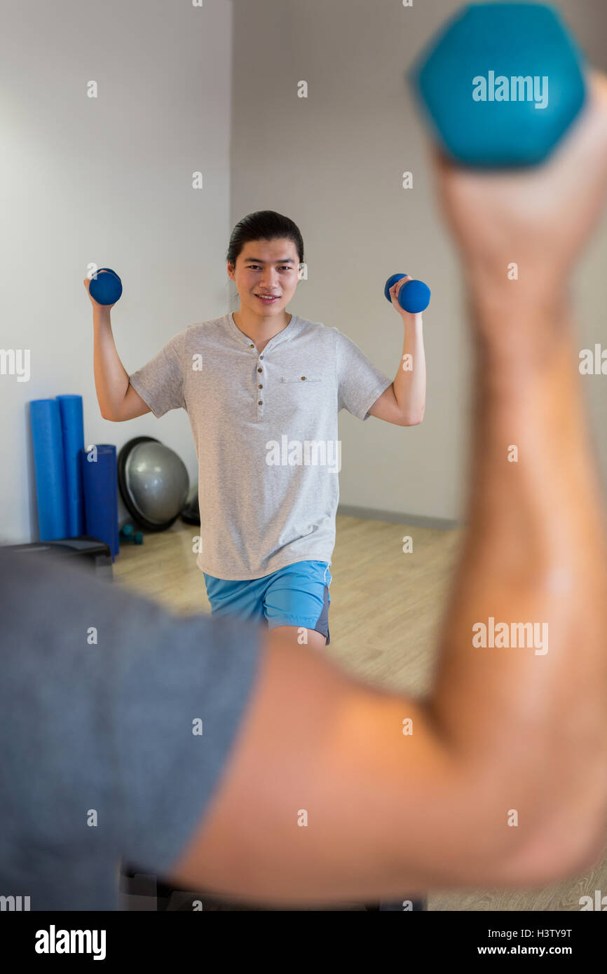Man doing step aerobic exercise with dumbbell on stepper Stock Photo ...