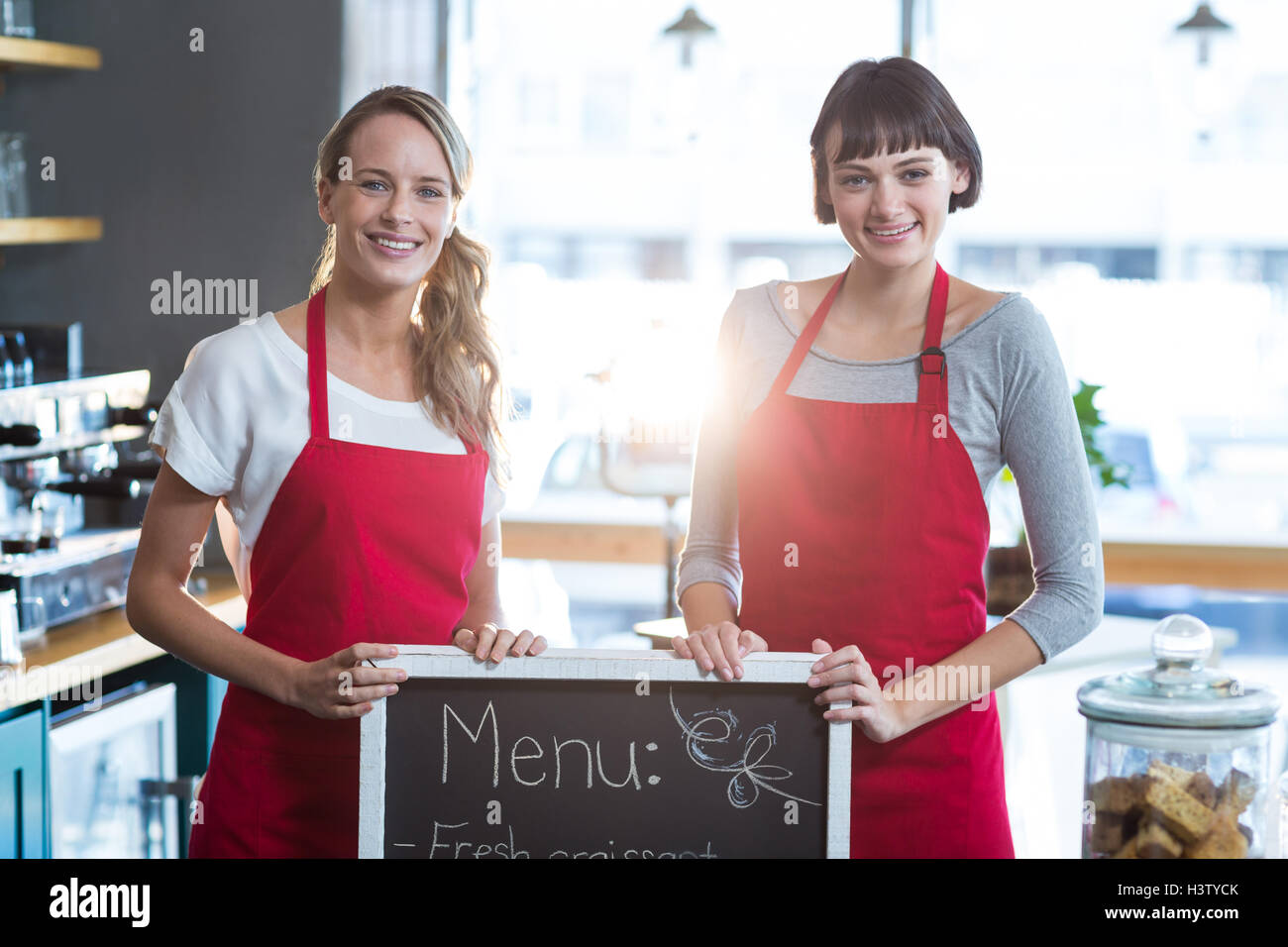 Smiling waitress standing with menu board in cafe Stock Photo - Alamy