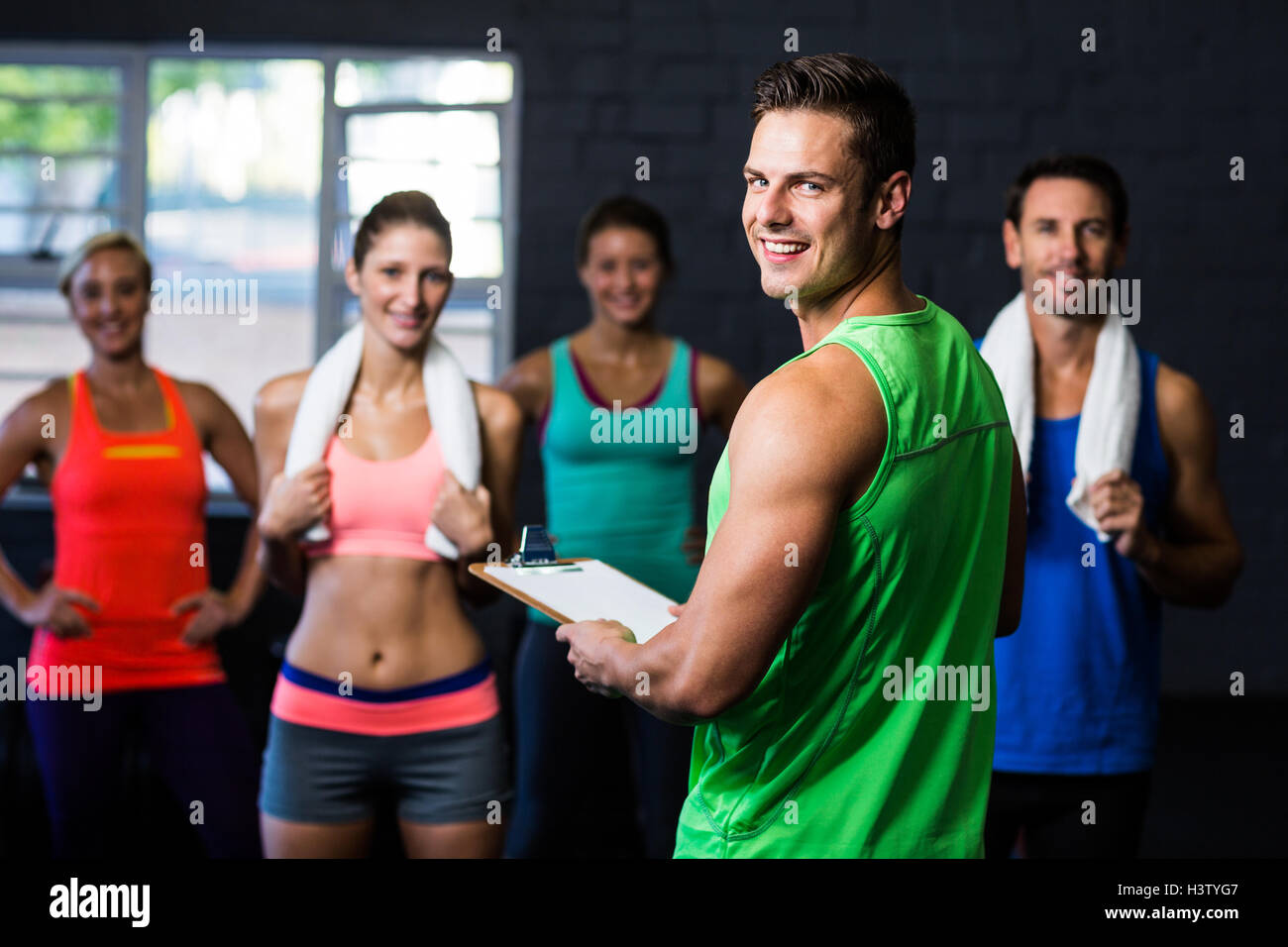 Portrait of cheerful fitness instructor with people in gym Stock Photo ...