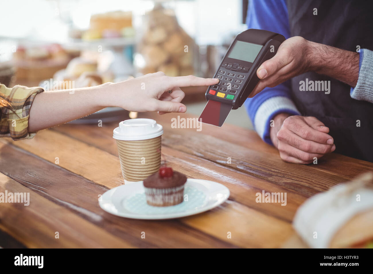 Customer entering pin number into machine at counter Stock Photo - Alamy
