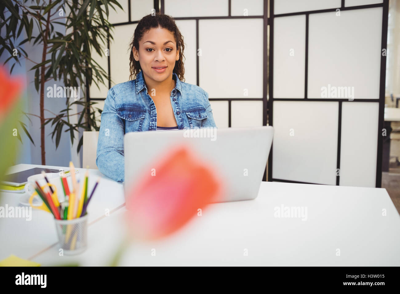 Smiling graphic designer at desk with laptop Stock Photo - Alamy