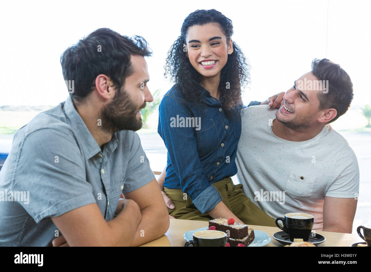Friends interacting with each other in coffee shop Stock Photo - Alamy