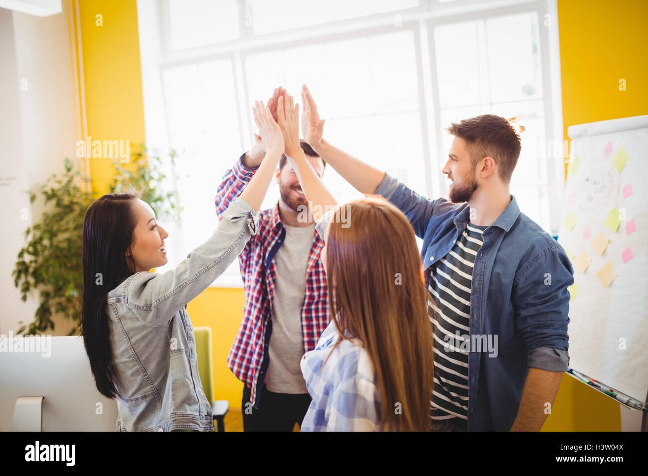 Successful graphic team giving high-five Stock Photo - Alamy