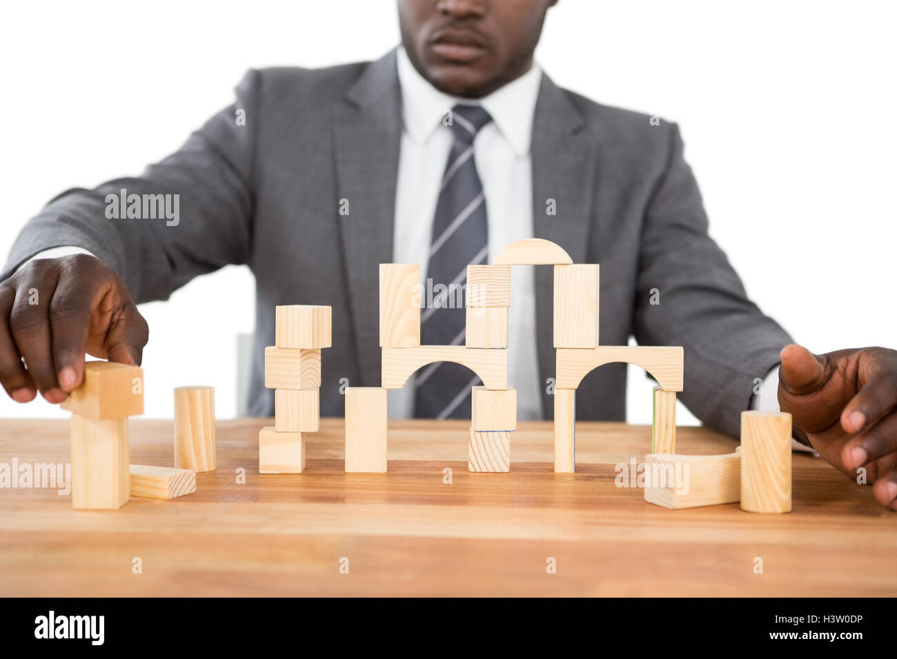 Businessman building tower of wooden blocks Stock Photo - Alamy