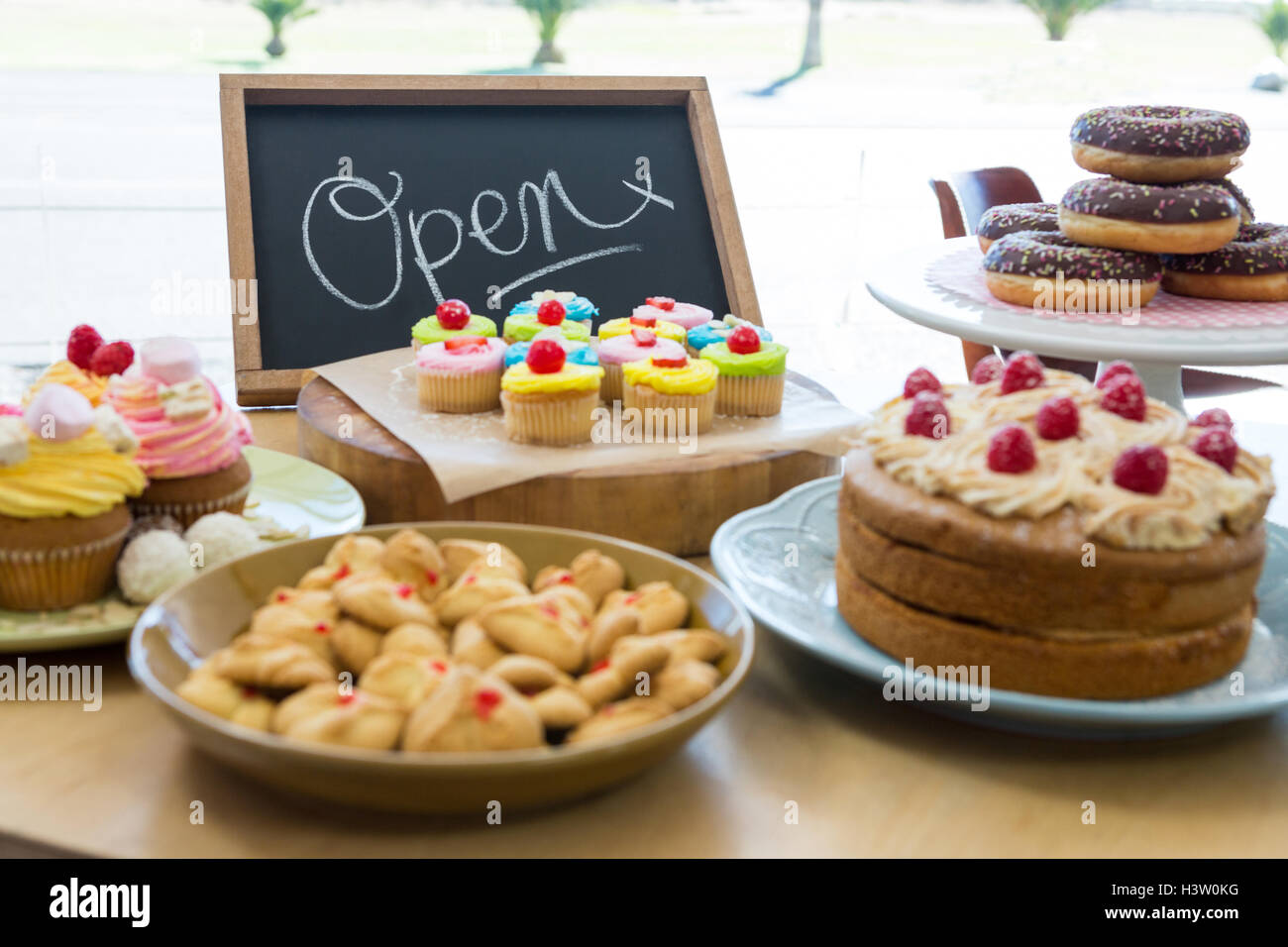 Close-up of various sweet foods on table with open signboard Stock ...