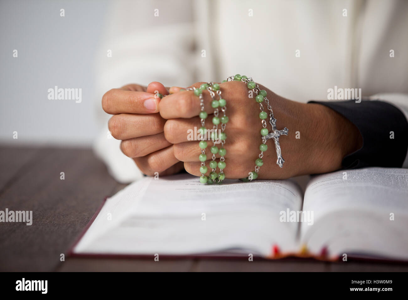 Praying hands of woman with a rosary on bible Stock Photo - Alamy
