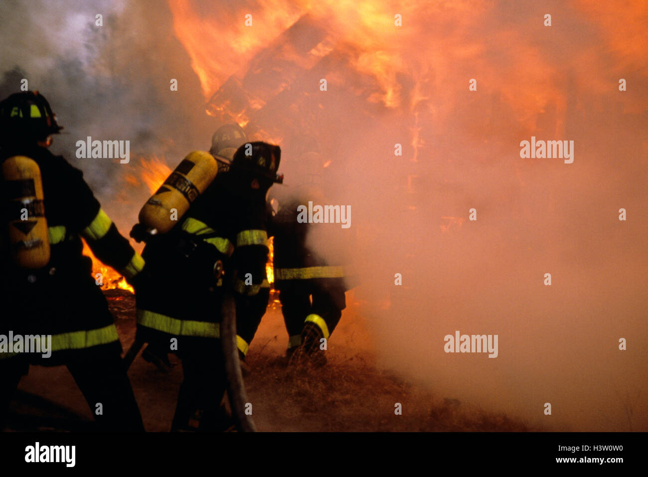 1990s ANONYMOUS FIREMEN RUSHING INTO FLAMES AND THICK SMOKE Stock Photo ...