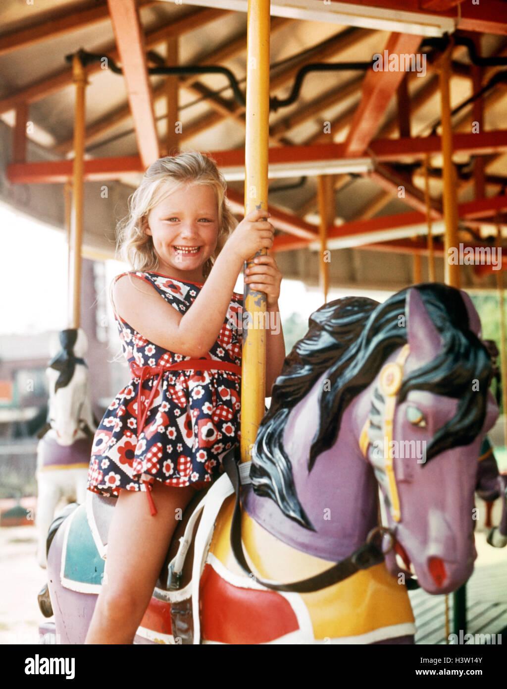 1970s SMILING GIRL PRINT DRESS SITTING CAROUSEL HORSE HOLDING POLE MERRY-GO-ROUND AMUSEMENT PARK ...
