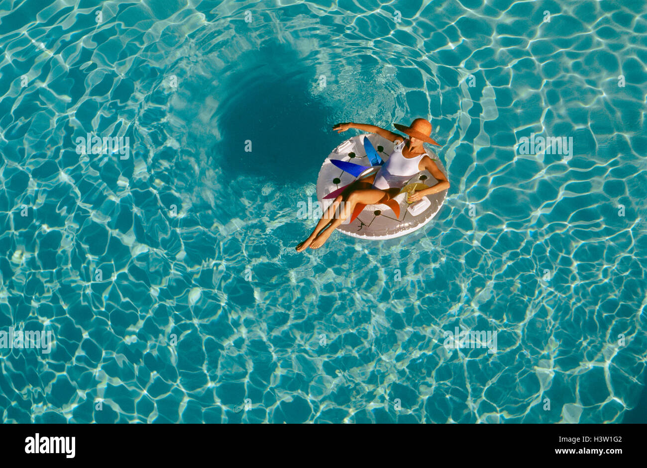 WOMAN SITTING ON FLOAT IN SWIMMING POOL Stock Photo - Alamy