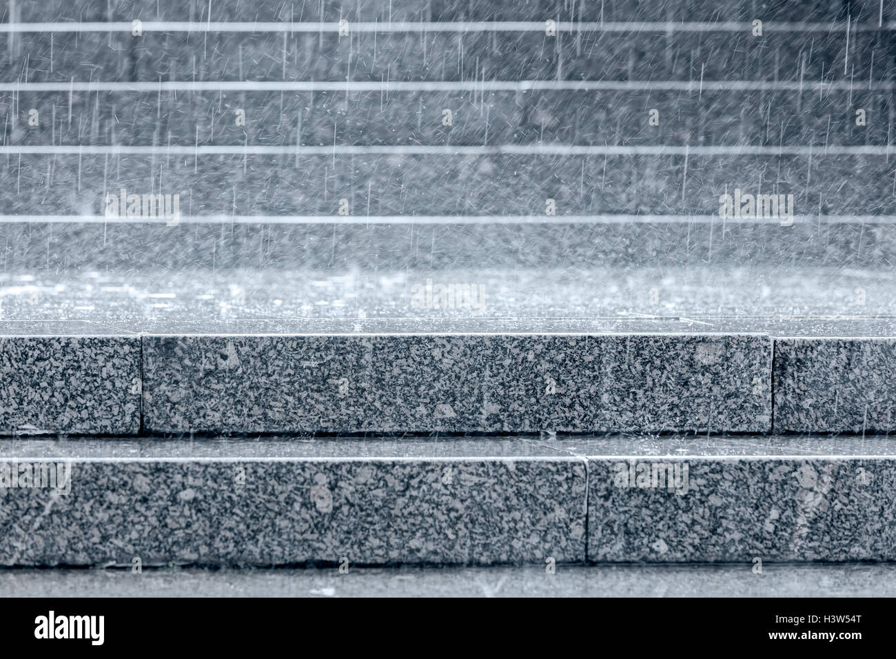 granite steps of staircase with raindrops falling on them during heavy ...