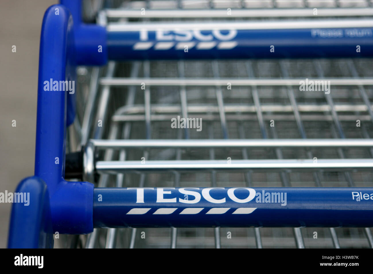 Tesco supermarket store shopping trolly handle with white on blue logo ...