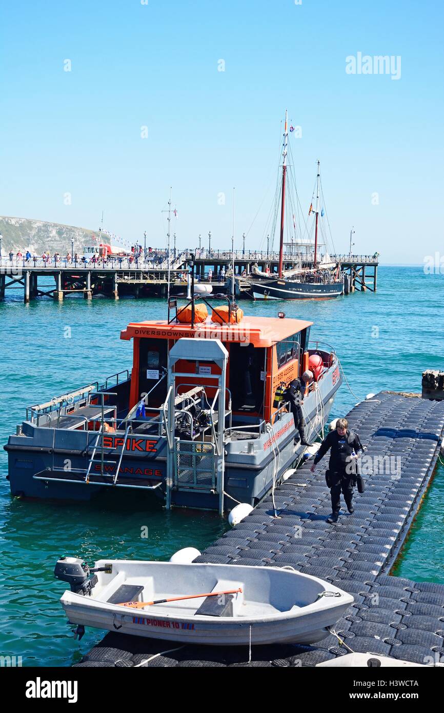 Dive boat moored alongside a pontoon with the pier to the rear, Swanage ...
