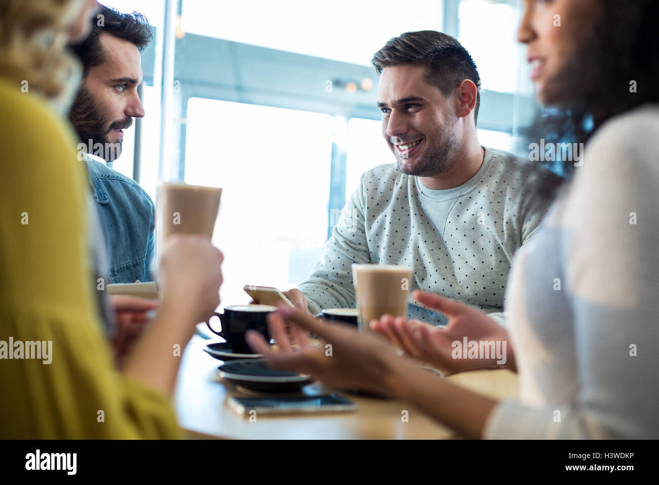 Smiling friends having a cup of coffee and cold coffee in caf├⌐ Stock ...